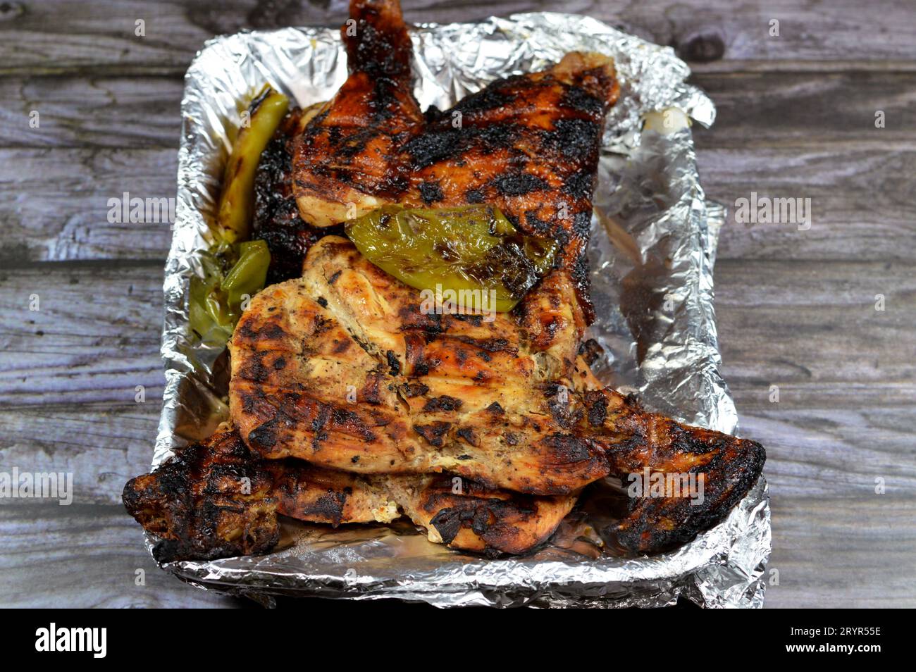 Chicken grilled and roasted on a charcoal grill, served on a disposable ...