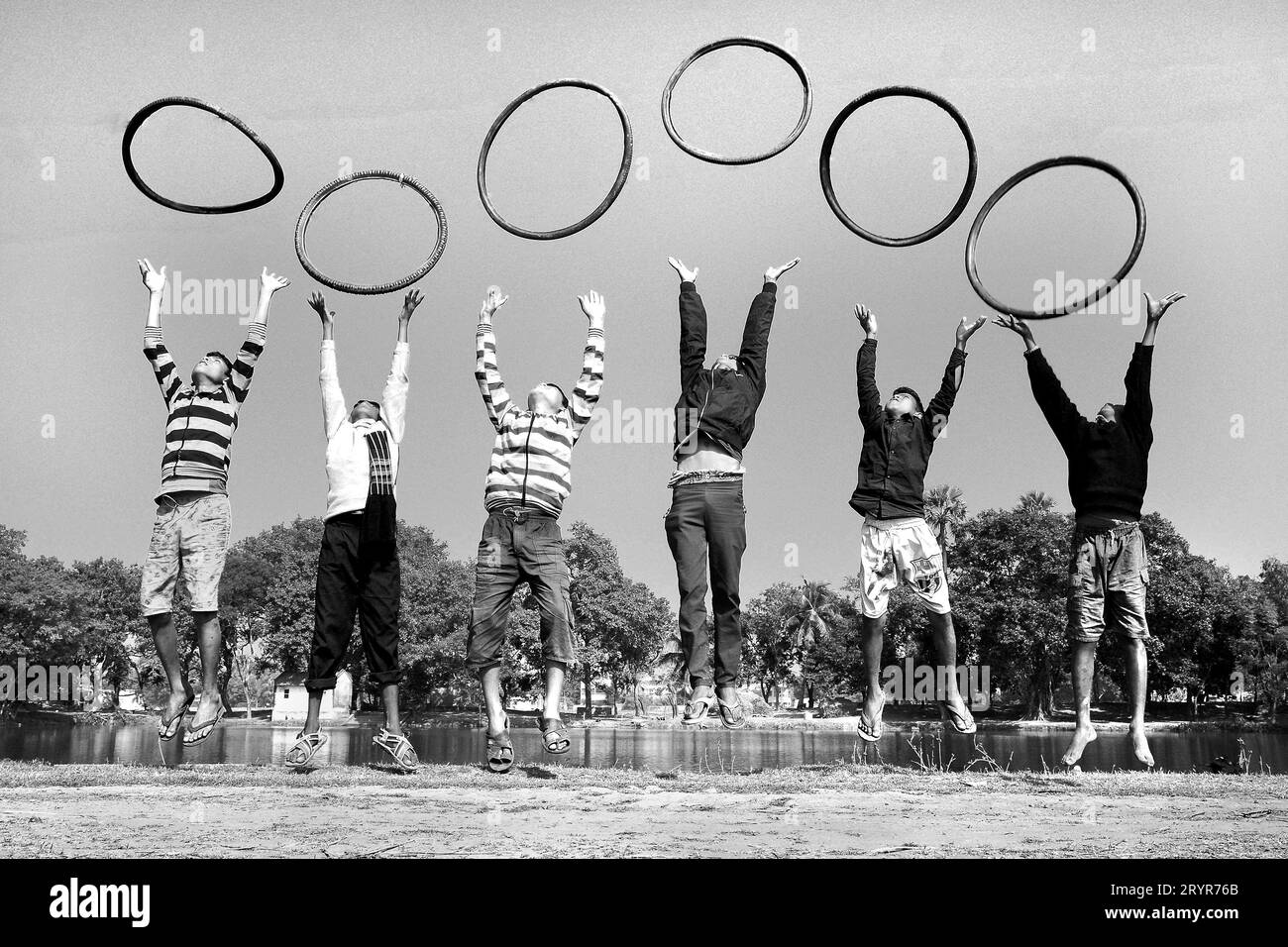 The rural village children are play with cycle tyres in the village ...