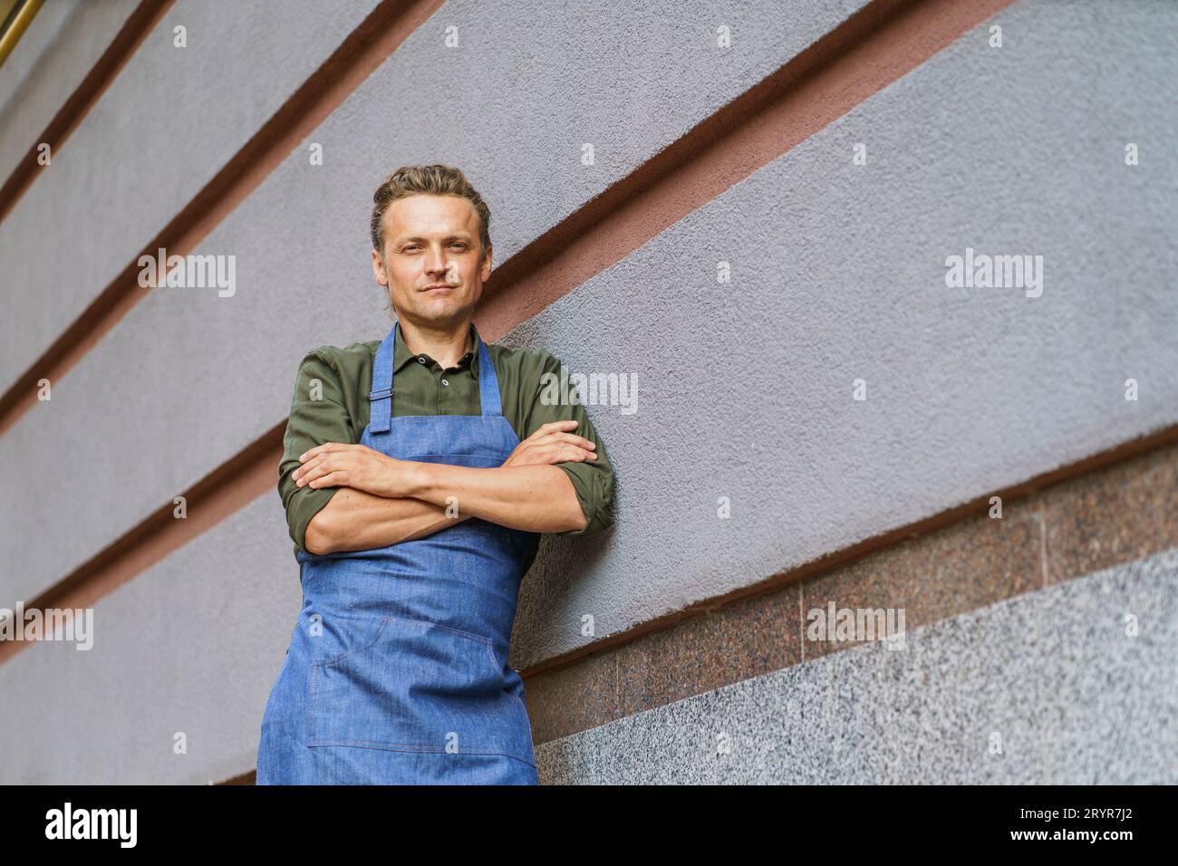 Service man, waiter or chef, in portrait against backdrop of restaurant ...