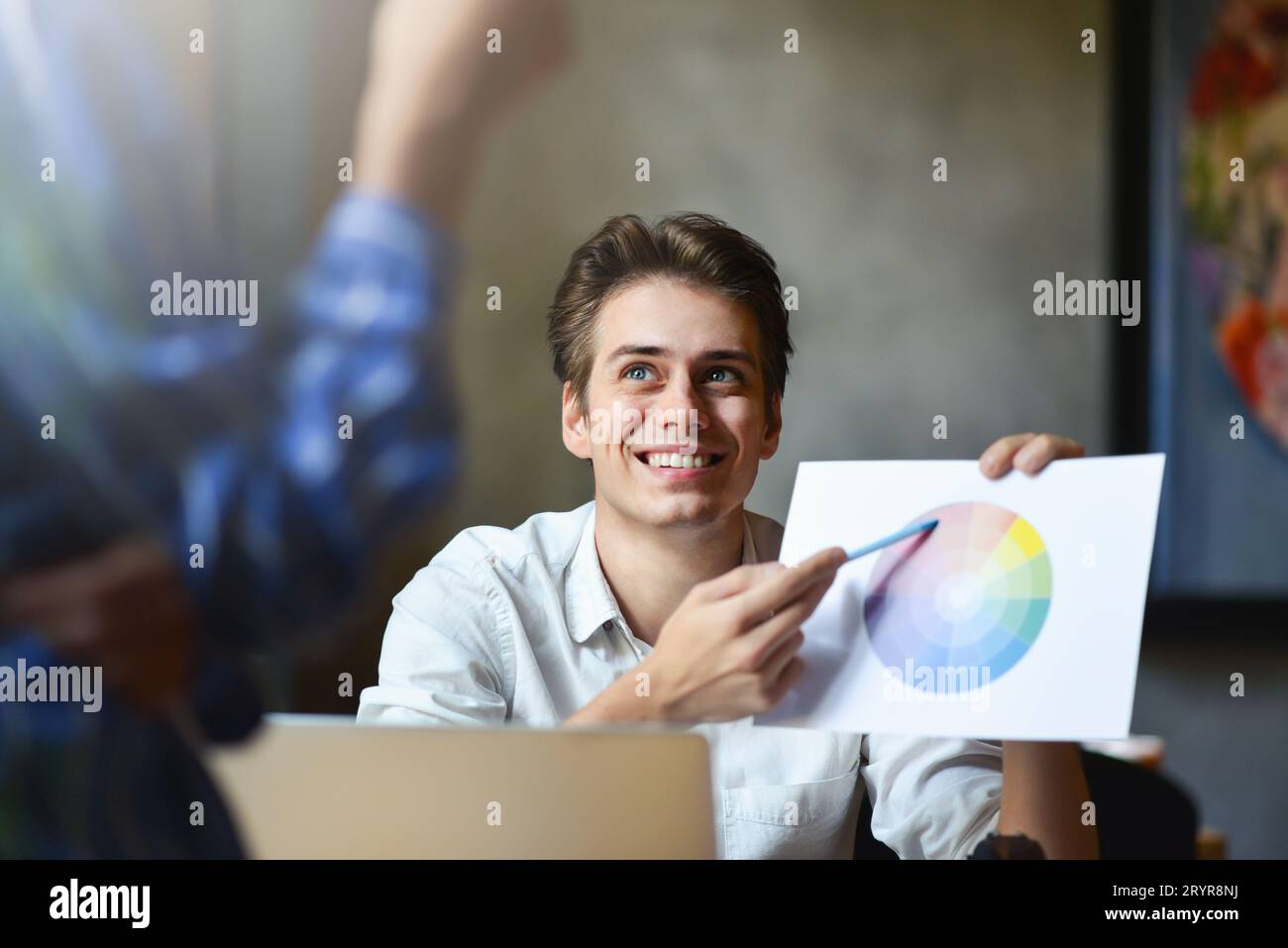 Happy graphic designer holding color diagram in his hand Stock Photo ...