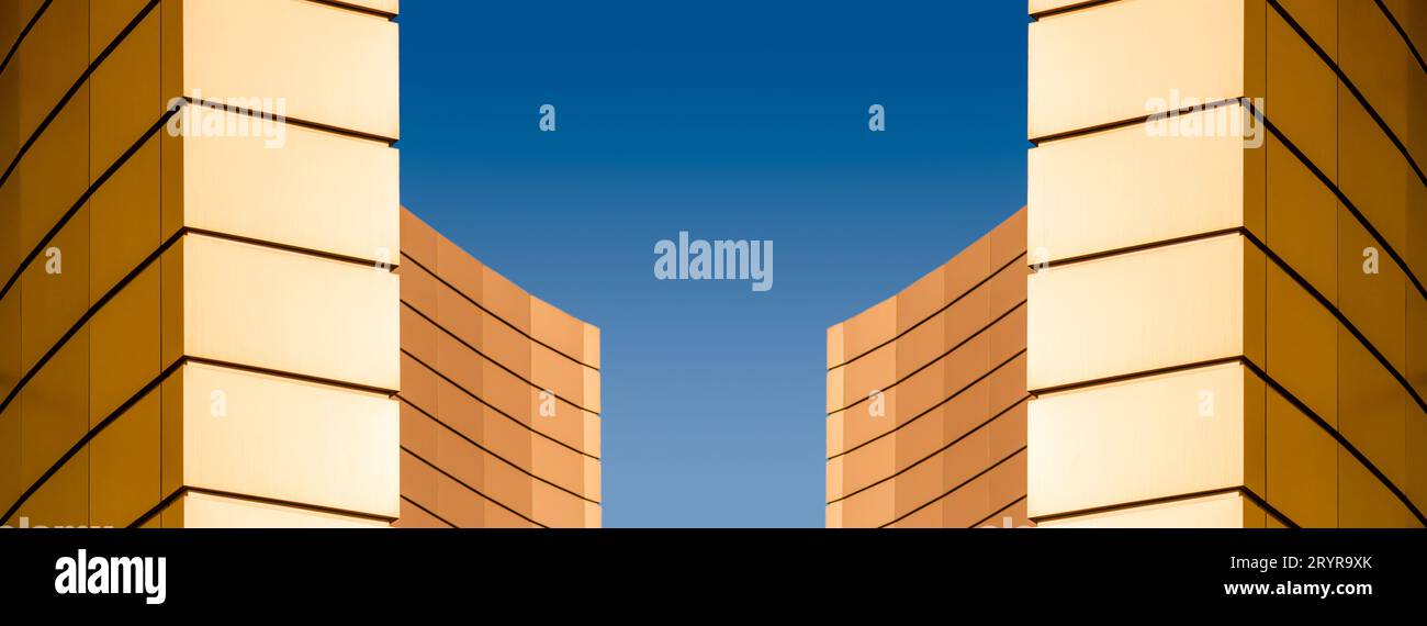 Fragment of the wall of a modern yellow building on a blue background ...