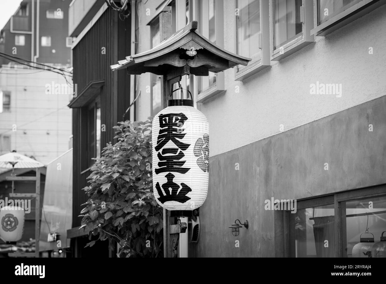 An illuminated vertical street lamp standing on a sidewalk in front of ...