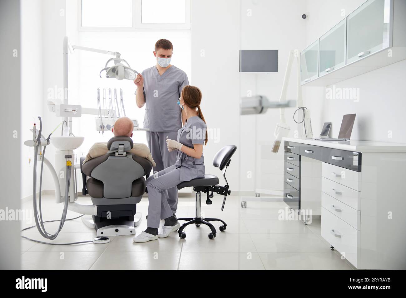 Hospital two doctors in medical uniform looking into sick pacient mouth analyzing teeth health ...