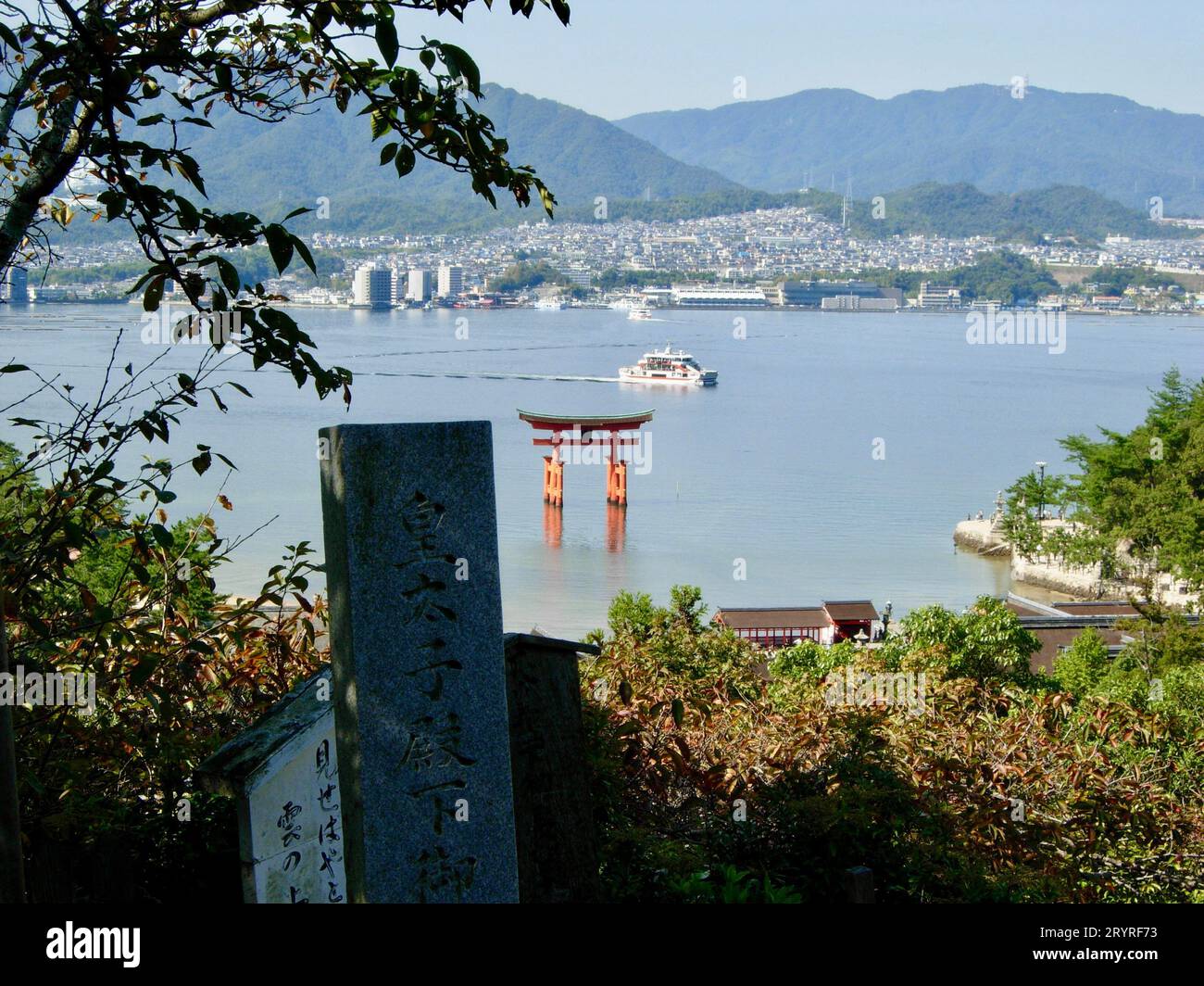 A traditional Japanese torii gate floating in a tranquil body of water ...