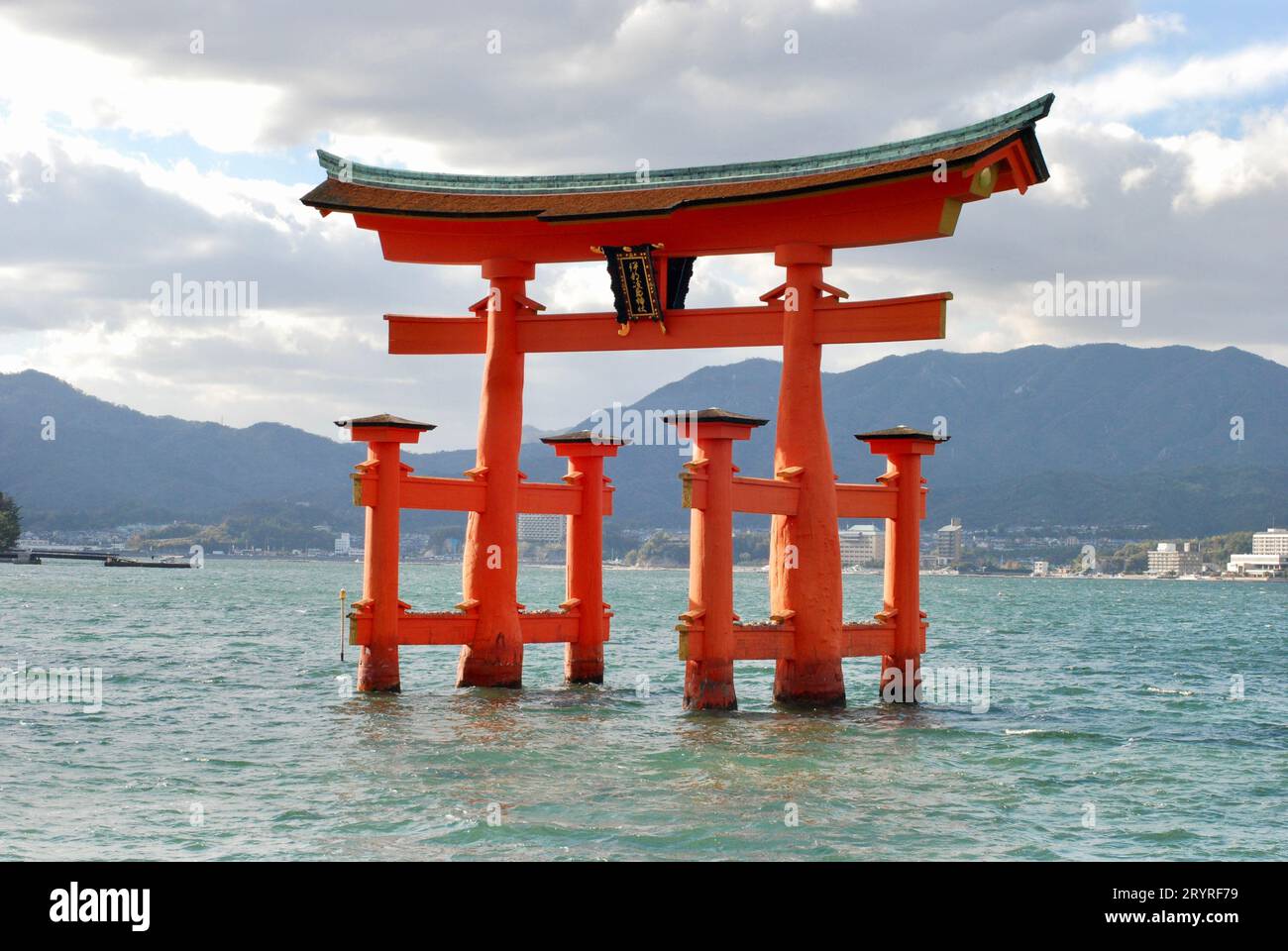 A traditional Japanese torii gate floating in a tranquil body of water ...