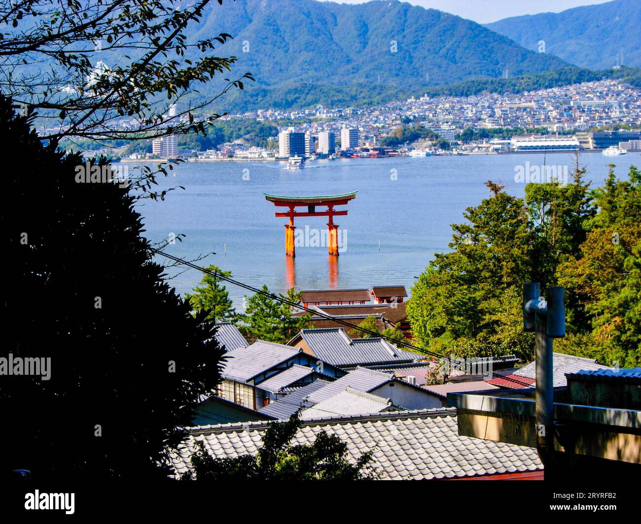 A traditional Japanese torii gate floating in a tranquil body of water ...