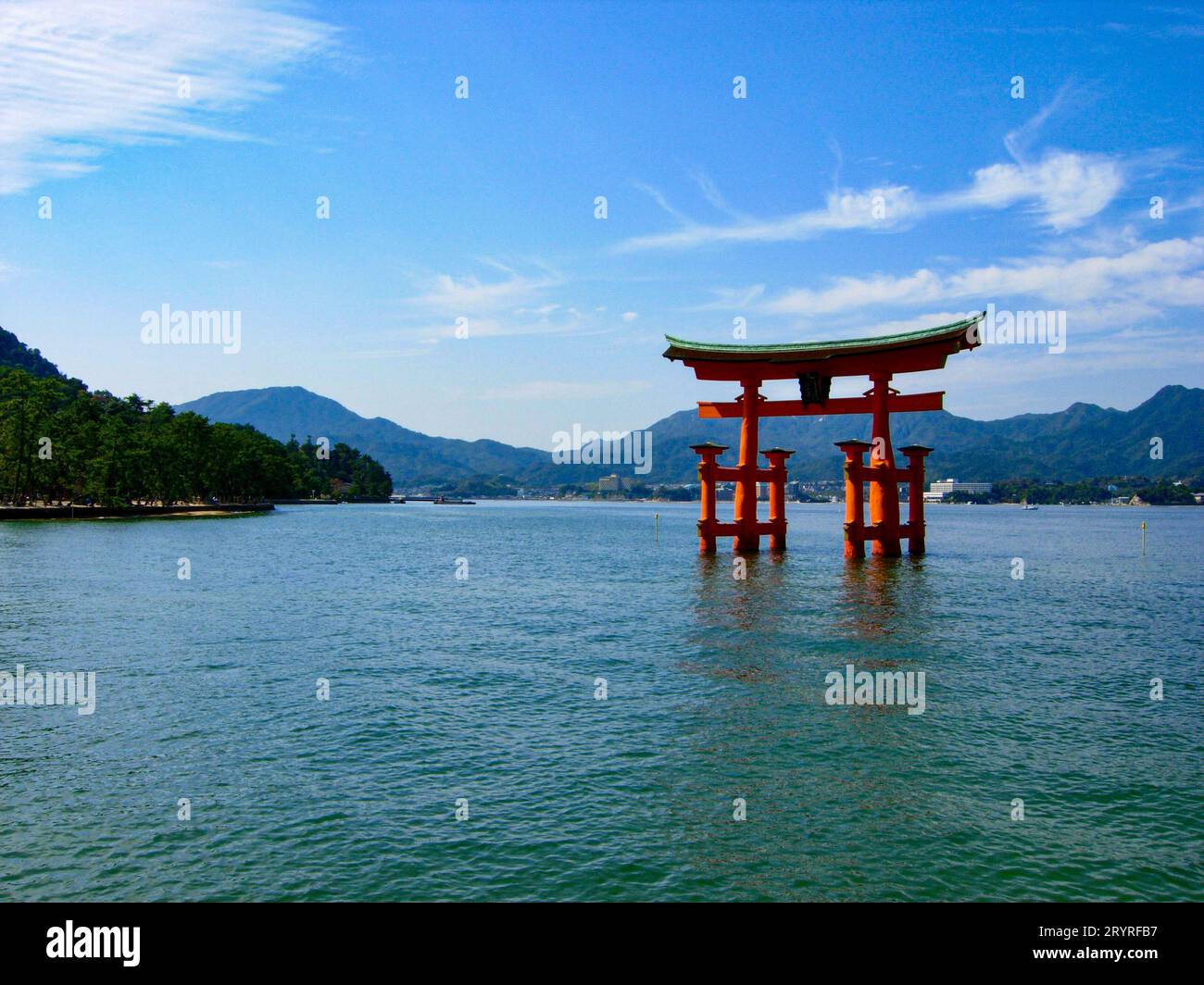 A traditional Japanese torii gate floating in a tranquil body of water ...