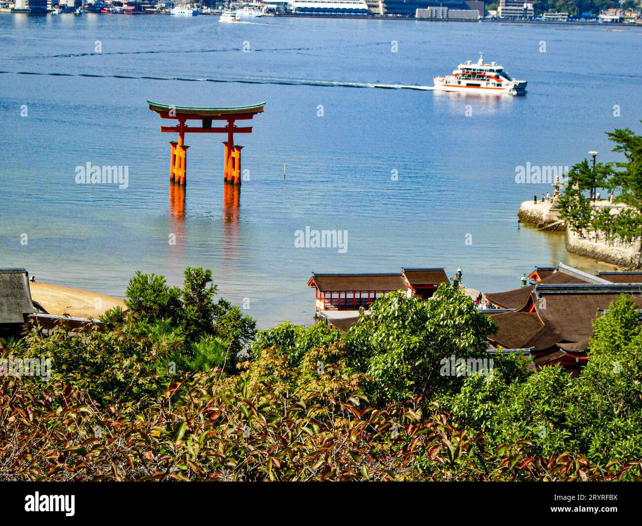 A traditional Japanese torii gate floating in a tranquil body of water ...