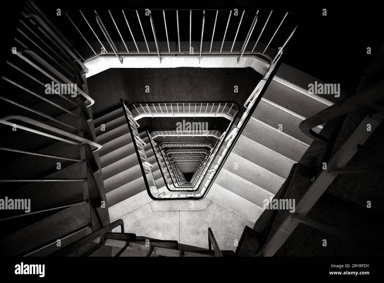 A top view of a modern spiral staircase leads to the upper levels of a ...
