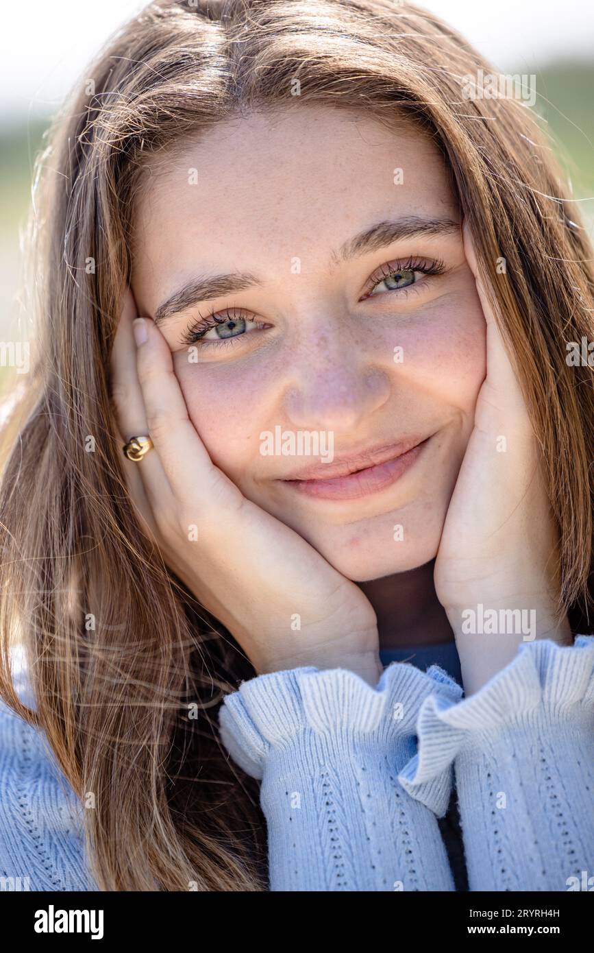 Happy beautiful girl holding her cheeks with a laugh, looking at the ...