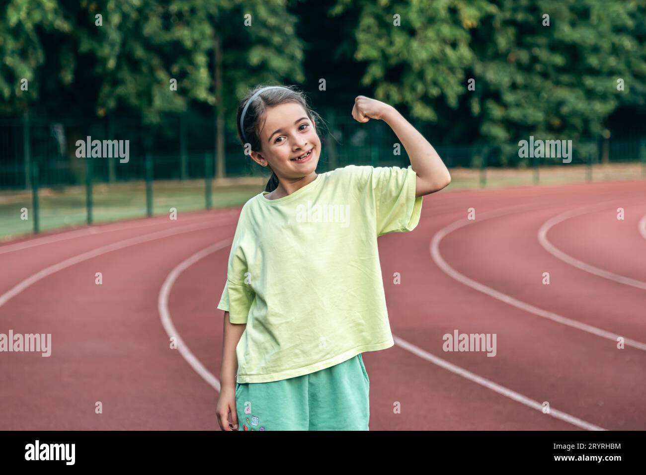 Strong little girl posing outdoors showing their muscles Stock Photo ...