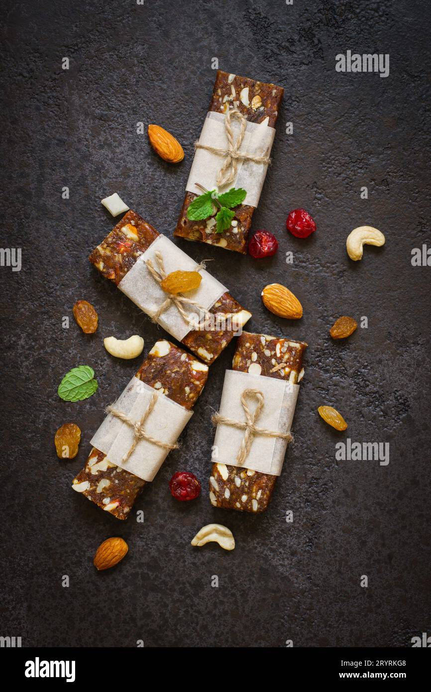 Healthy snack bars of dried fruits and nuts on black concrete ba Stock ...