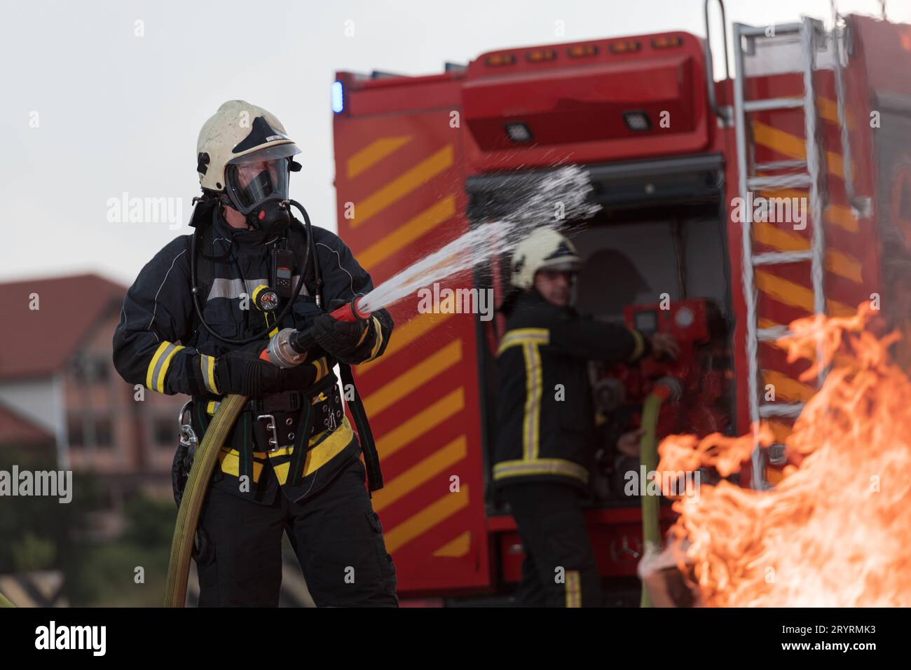 Firefighters using water fog type fire extinguisher to fighting with ...
