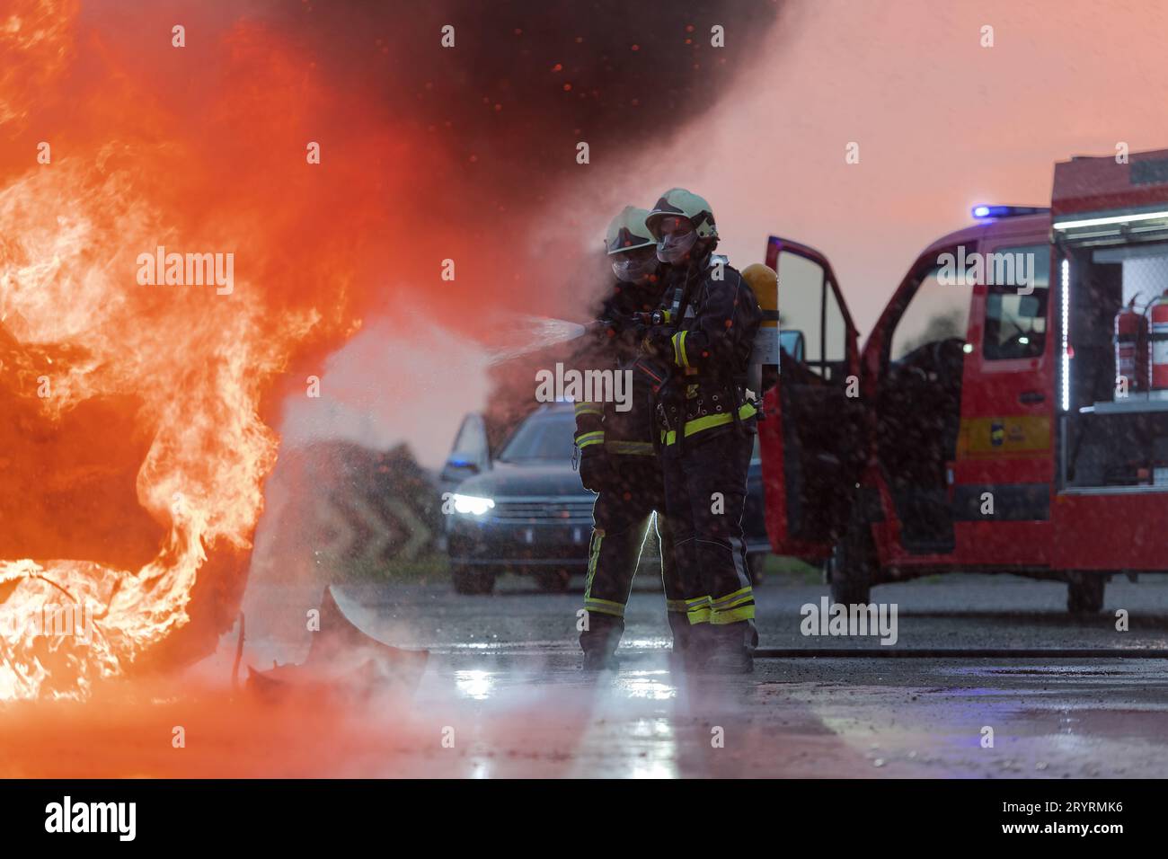 Firefighters using water fire extinguisher to fighting with the fire ...