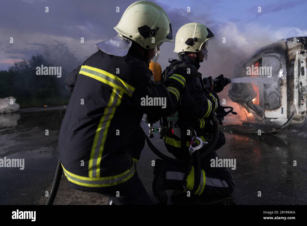 Firefighters using water fire extinguisher to fighting with the fire ...