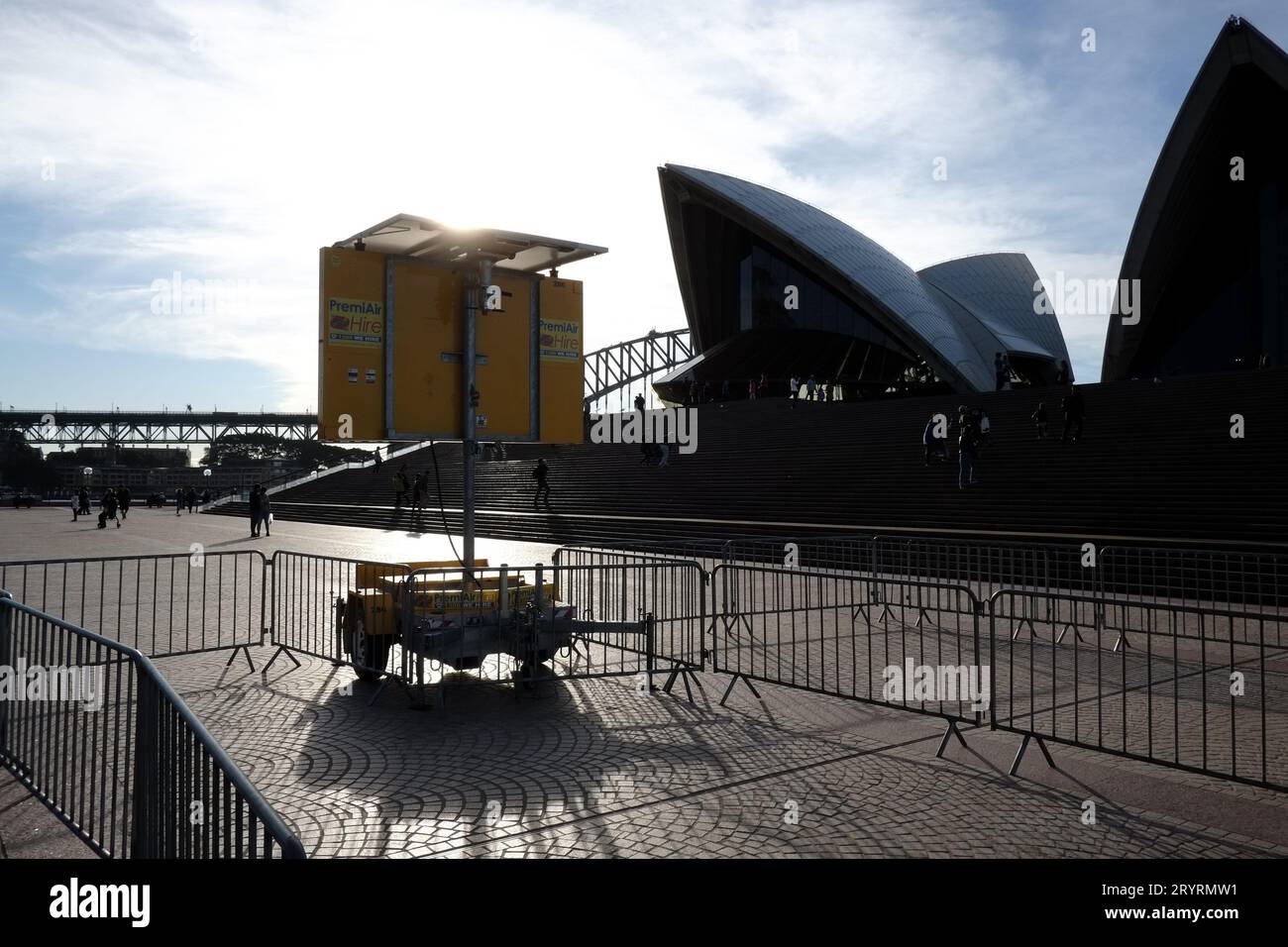 A mobile electronic sign (from behind) and a ring of metal barricades ...