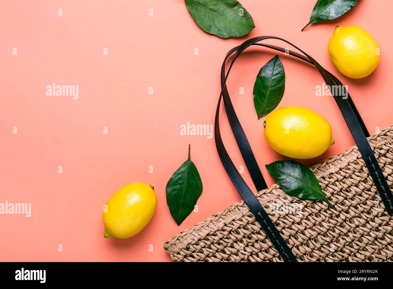 Natural straw bag and ripe lemons on Living coral background Stock ...