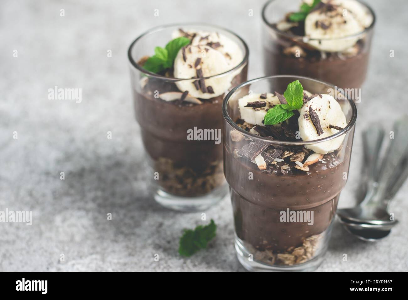 Chocolate pudding with chia and banana in glasses. Healthy dessert or ...