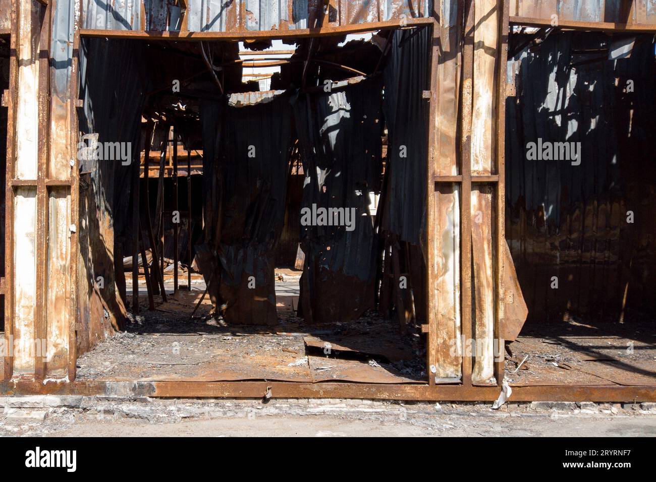 Charred remains of market stalls and metal structures after a fire ...