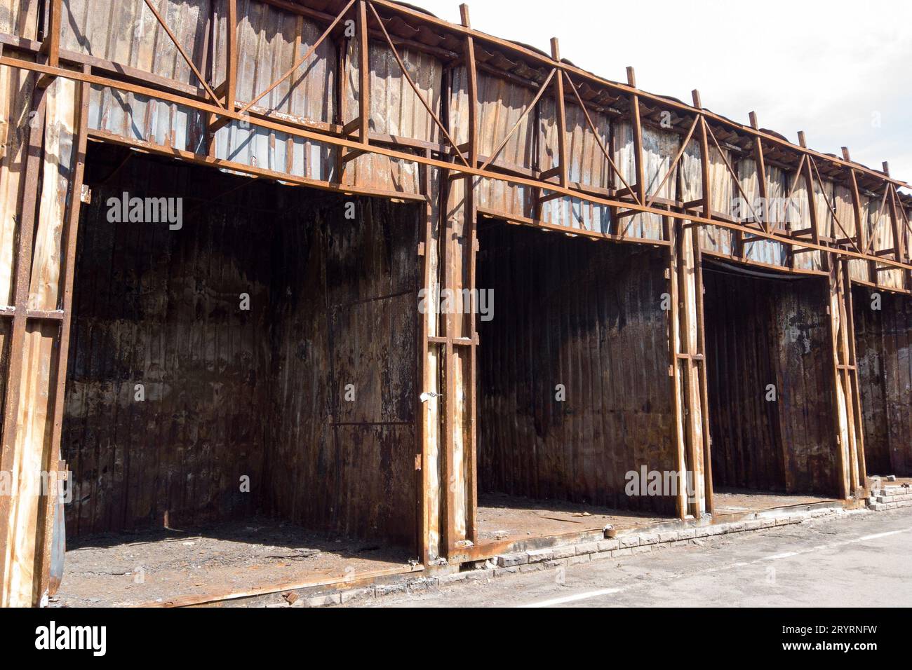 Charred remains of market stalls and metal structures after a fire ...