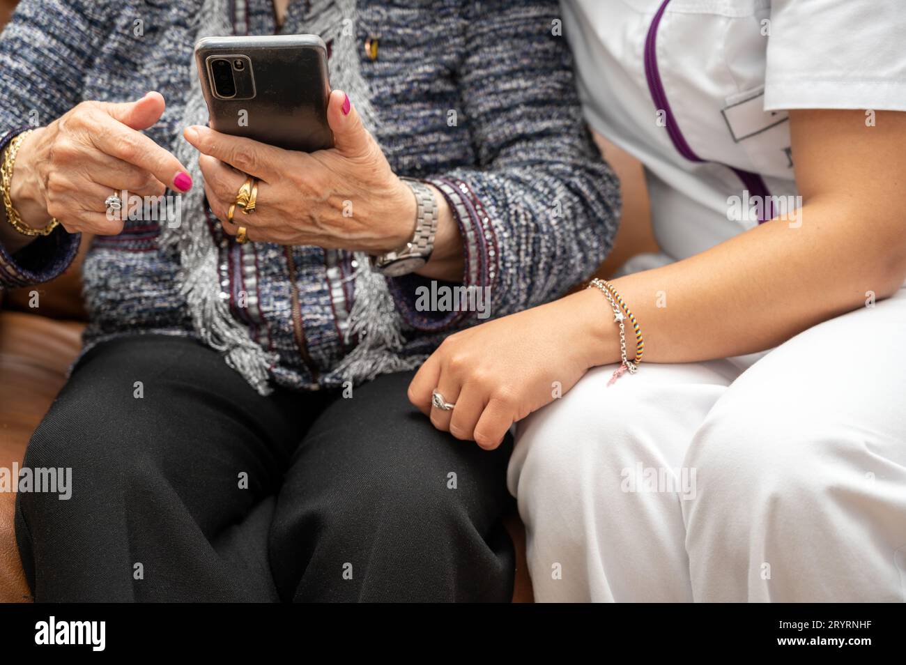 Nurse teaching elder woman how to use mobile phone, senior grandmother ...