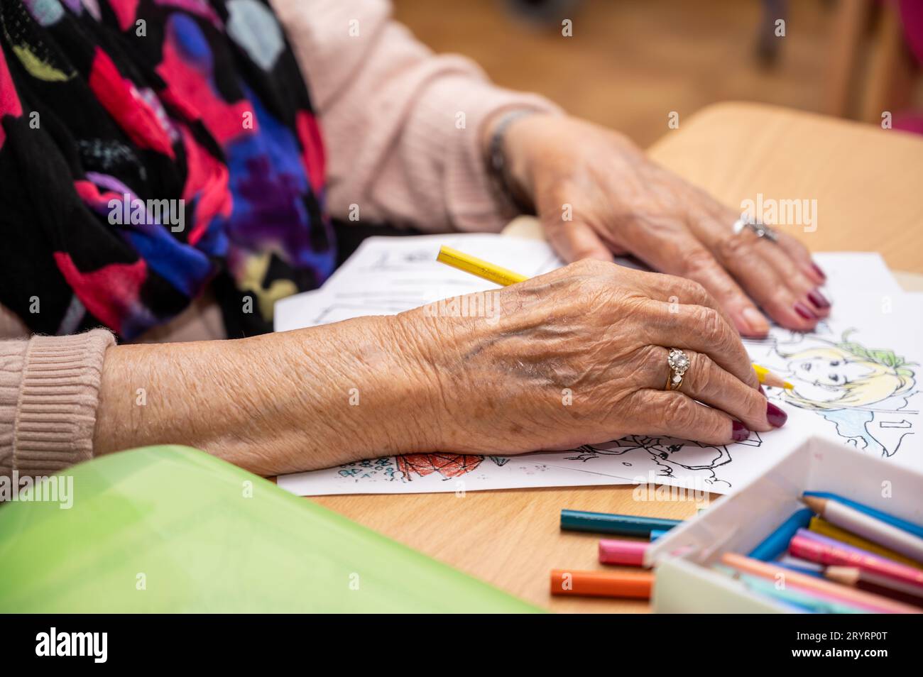 Elderly woman painting color on her drawing. Hobby at nursing home ...