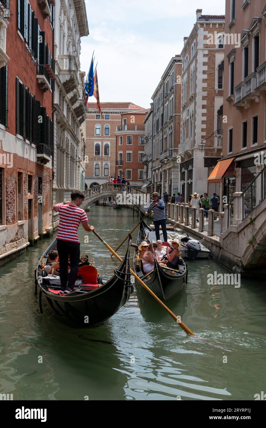 Two gondolas heading in opposite directions in a backwater canal near ...