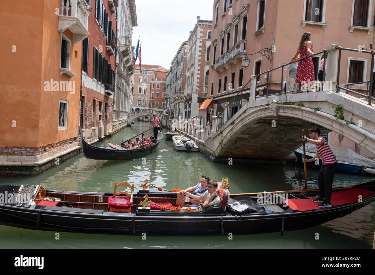A busy junction as two canals meet next to a low footbridge as two ...