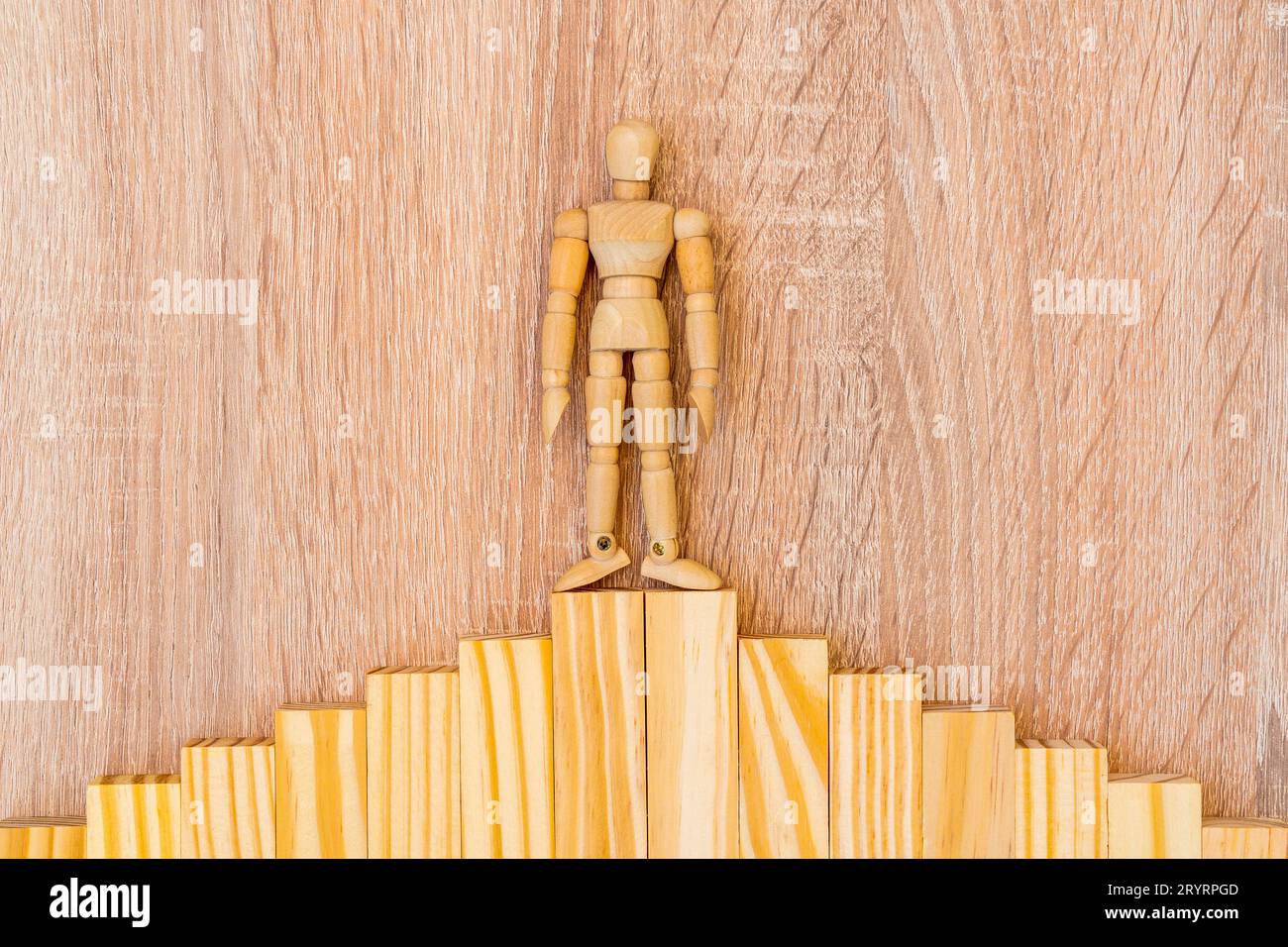 Wooden man standing on the top of wooden blocks Stock Photo - Alamy