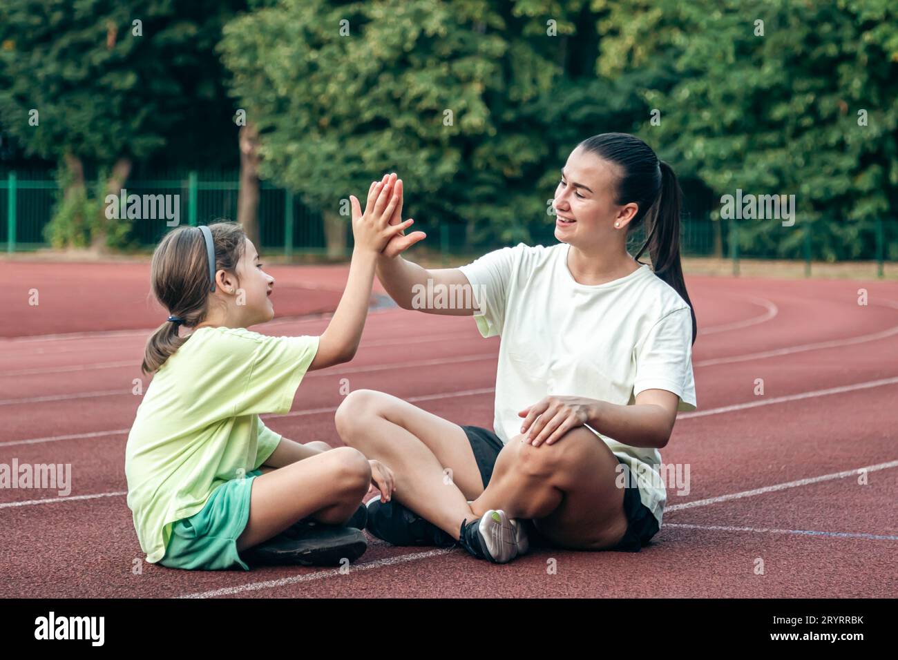 Strong mother and daughter giving high five at the stadium Stock Photo ...