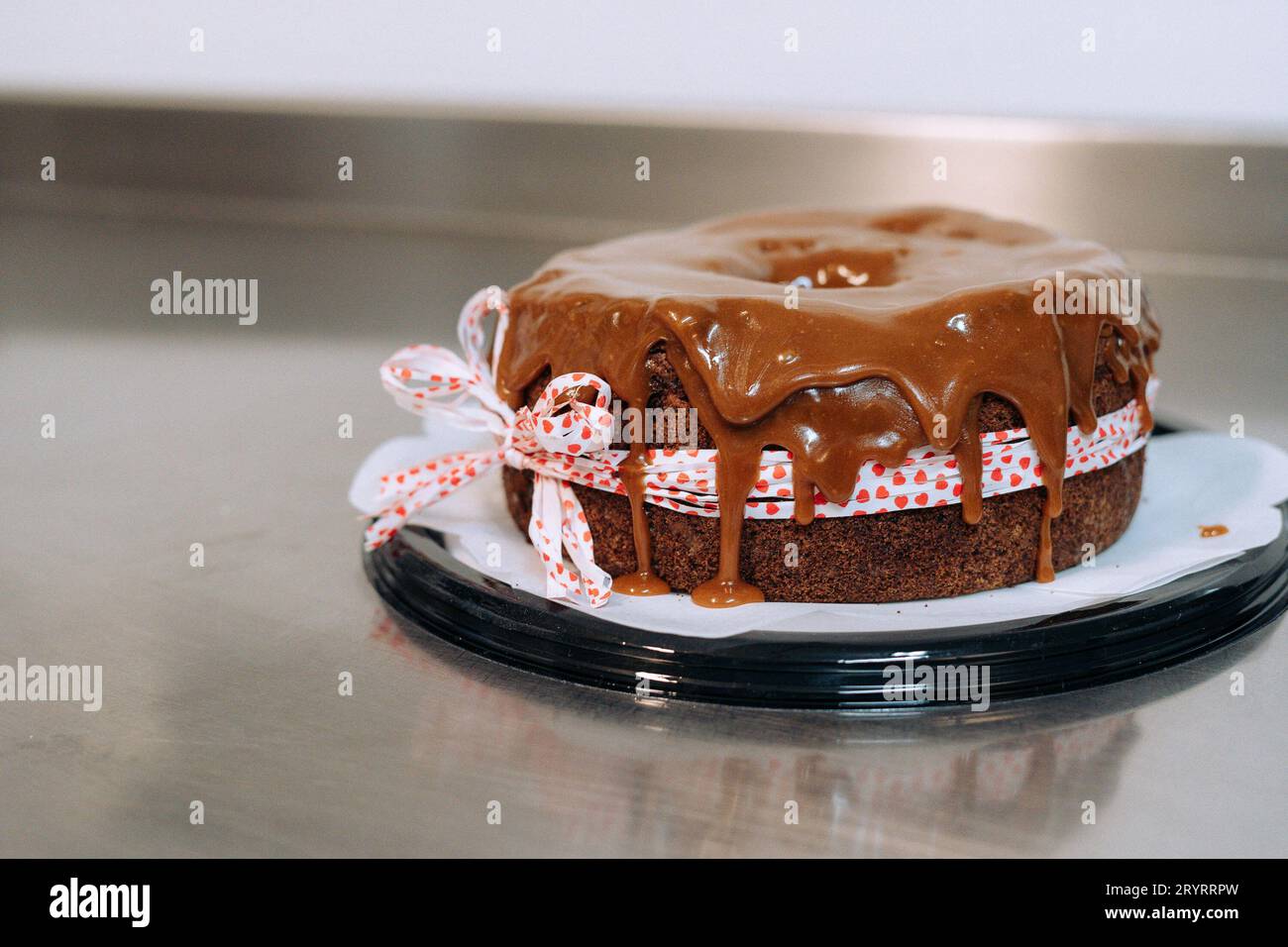 A delicious chocolate cake with a smooth frosting tied in a ribbon bow ...