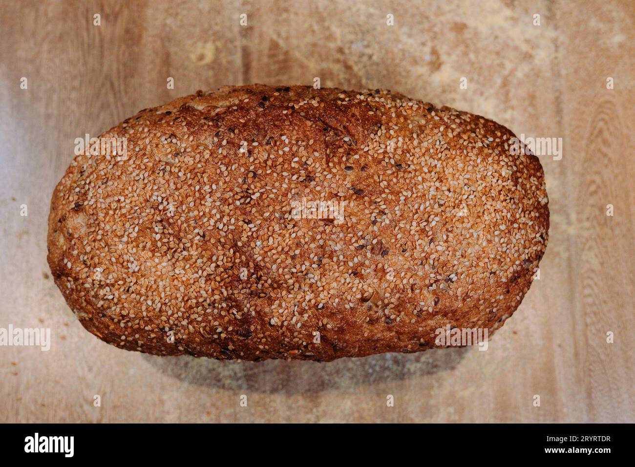 A top view of a freshly baked loaf of bread resting atop a rustic ...