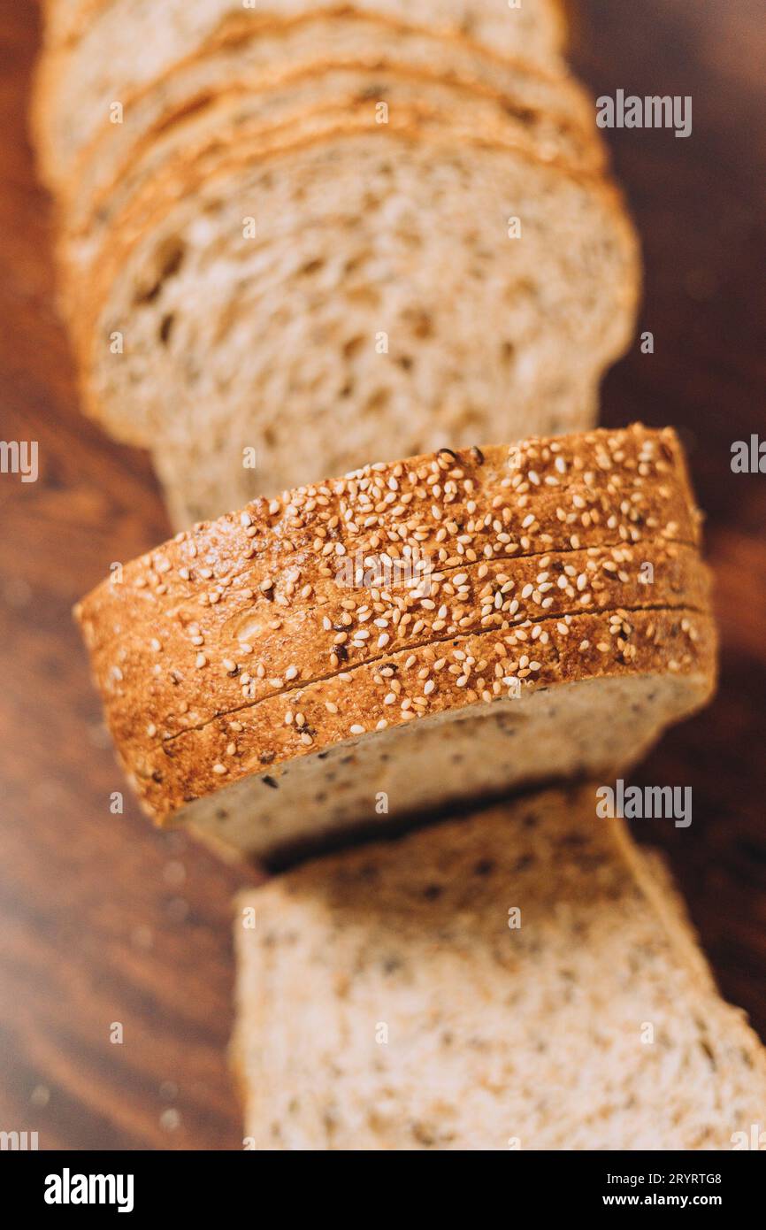 A vertical shot of a loaf of freshly sliced artisan bread, topped with ...