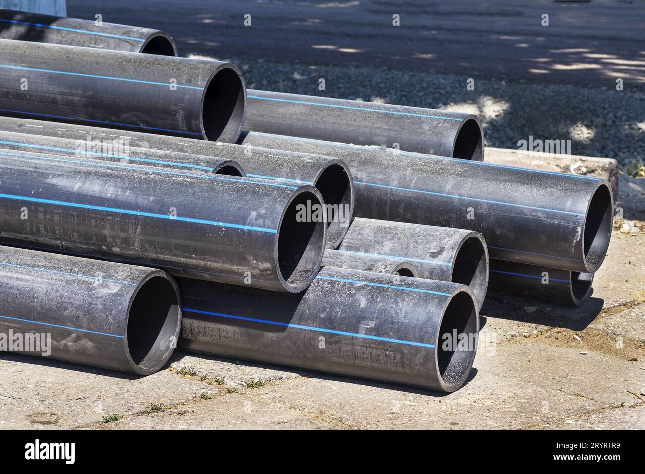 Plastic main black pipes. A heap of polyethylene pipes for a water ...