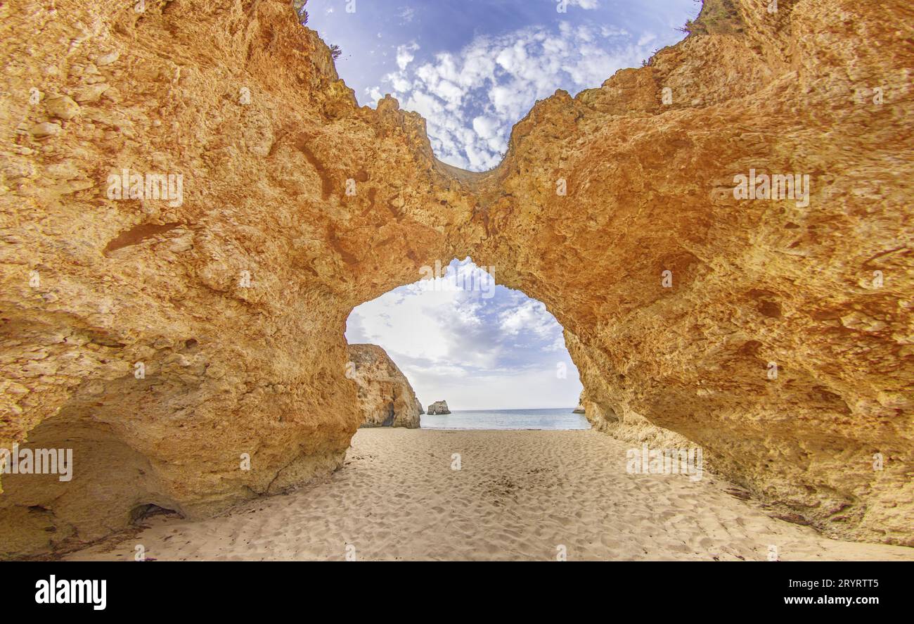 A picturesque coastal landscape featuring a dramatic rocky cave ...