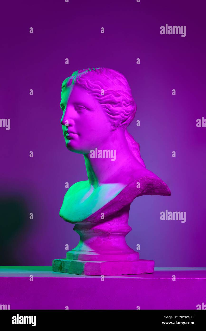 Greek sculpture. Plater copy of antique statue bust against purple ...