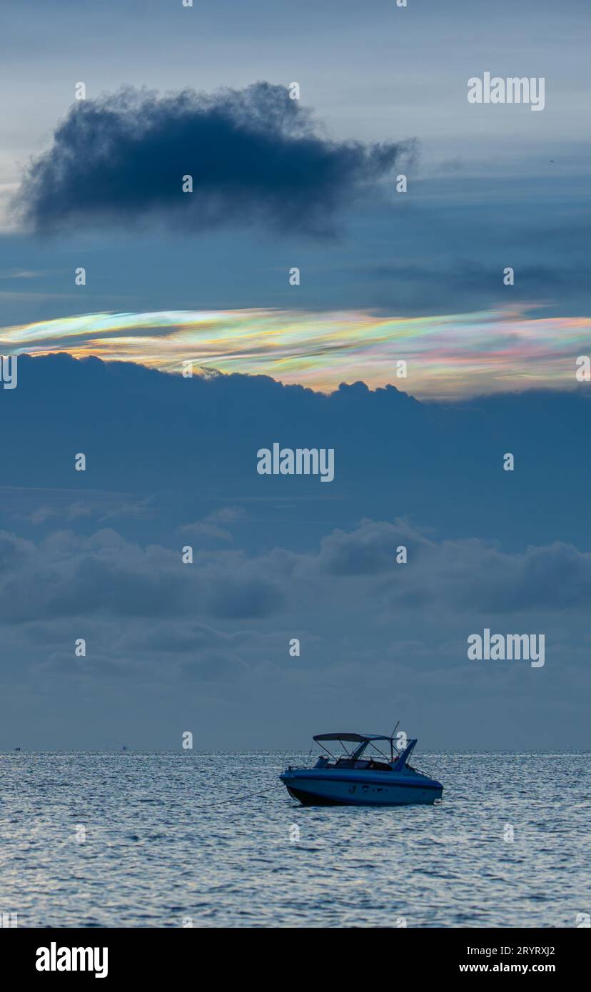 A vertical shot of a boat sailing along the blue ocean under a ...