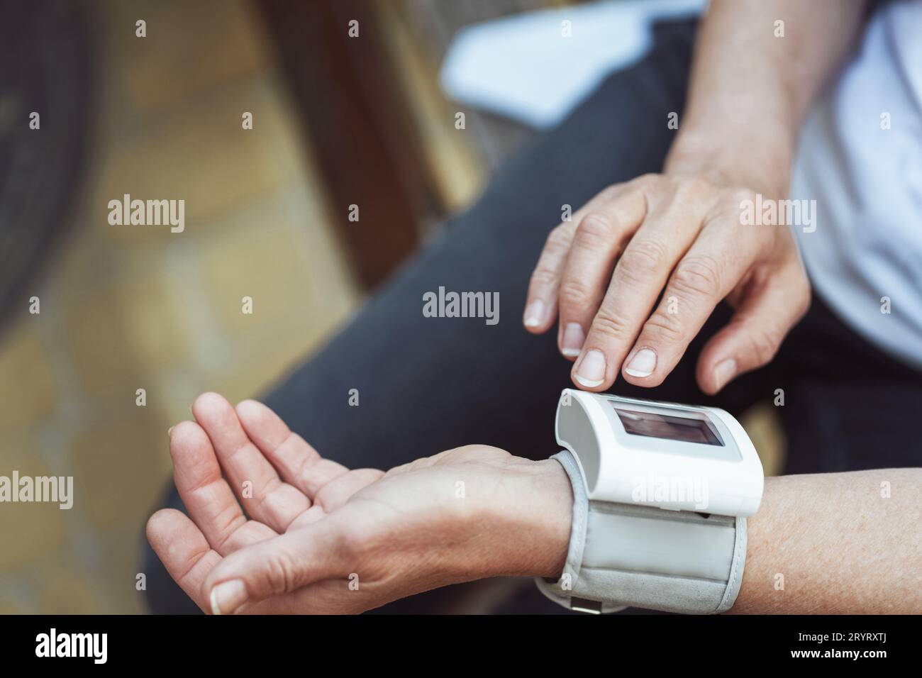 Old senior lady using pressure measuring apparatus to measure her blood ...