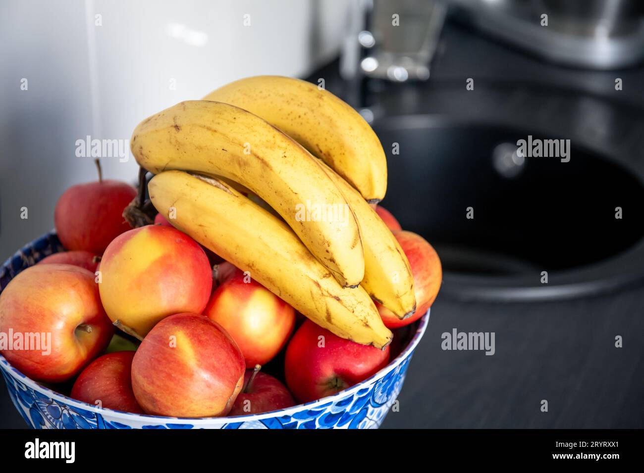 A bunch of bananas and apples in the kitchen near the sink Stock Photo ...