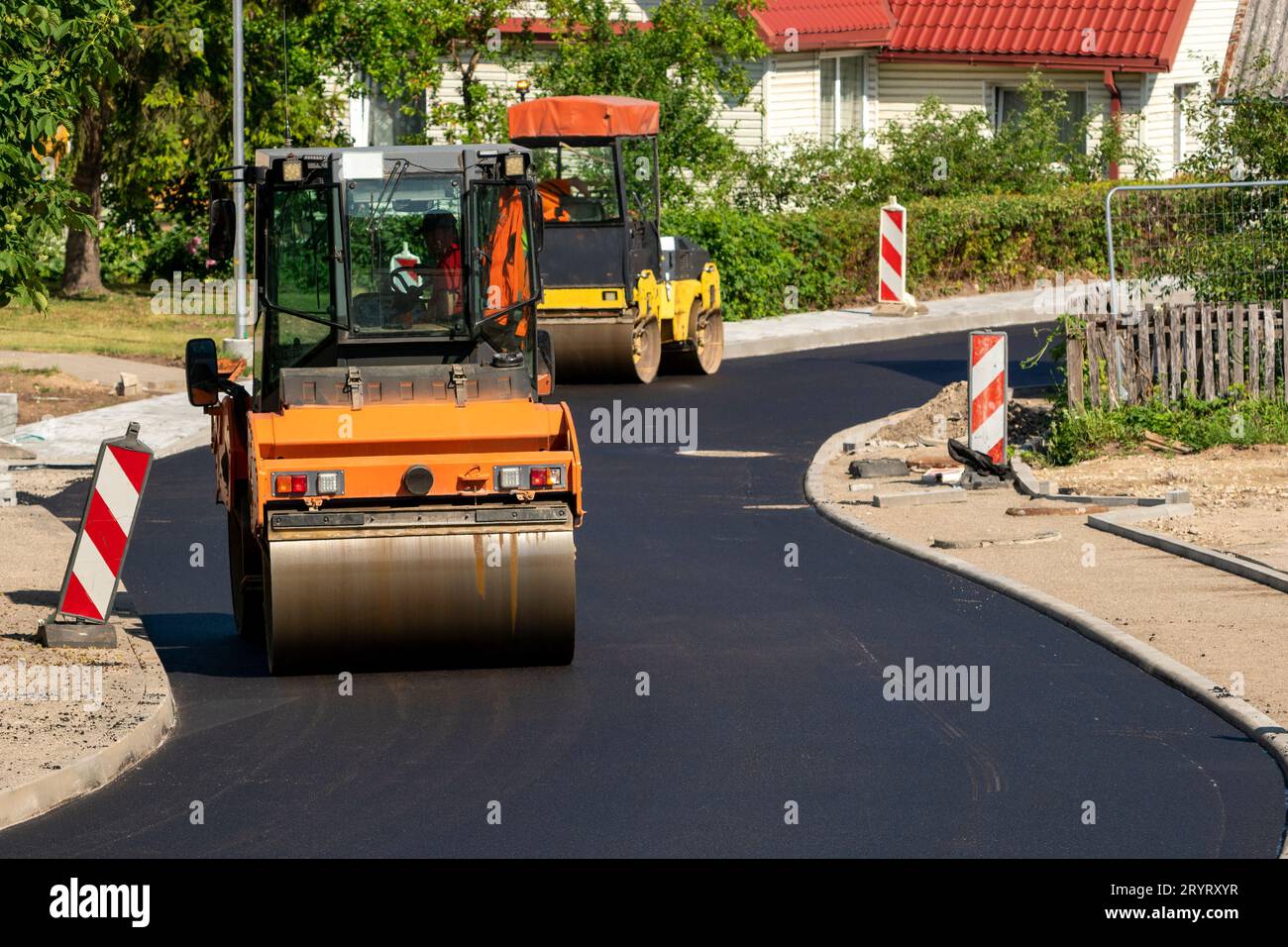 Two special autos paving new asphalt driving in line one near another ...