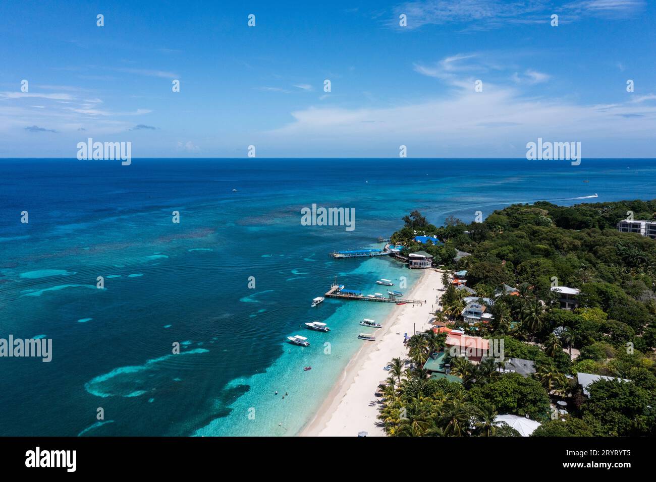 An aerial view of a coastal beach with crystal blue waters and white ...
