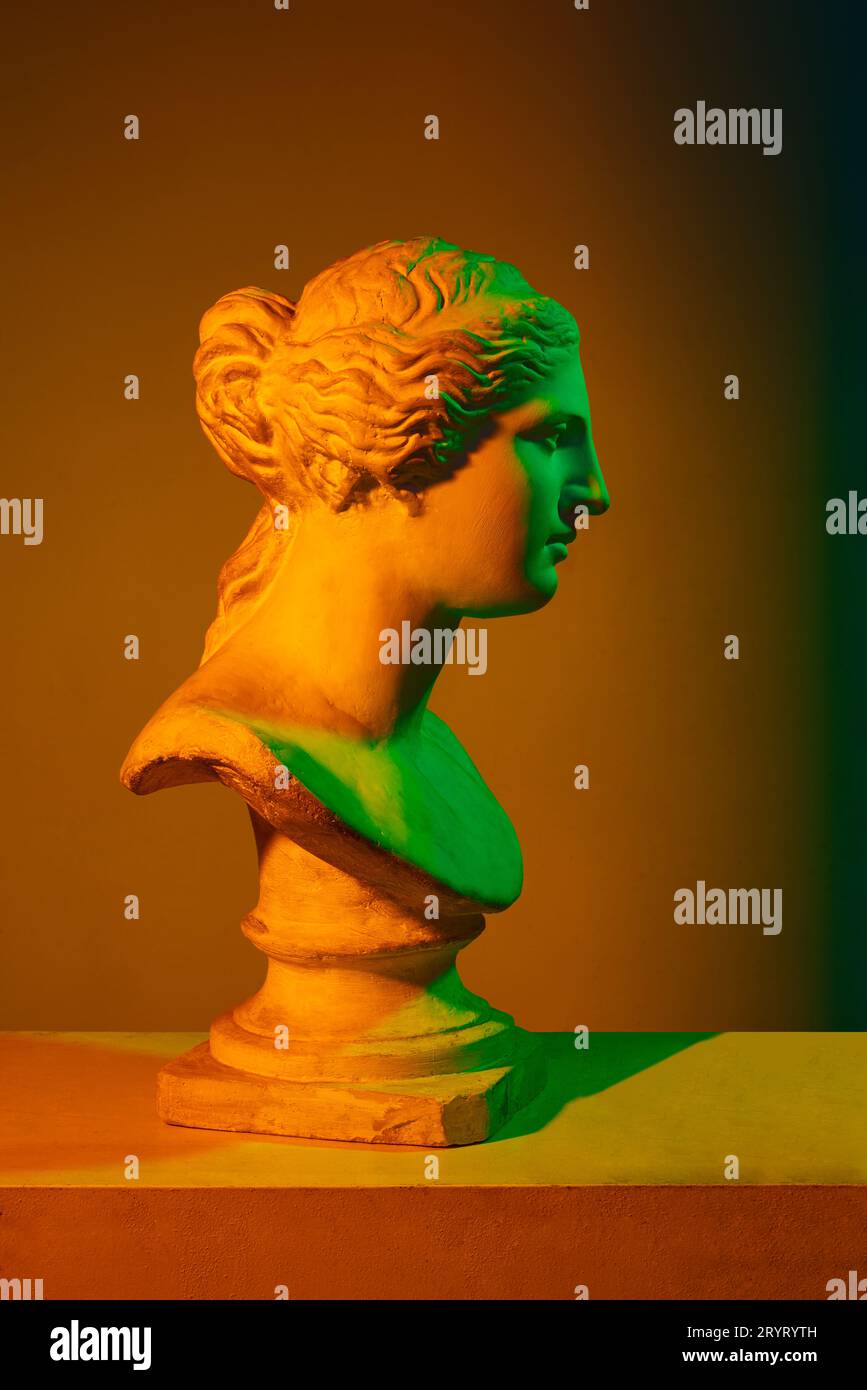 Greek sculpture. Plaster copy of antique statue bust against orange ...