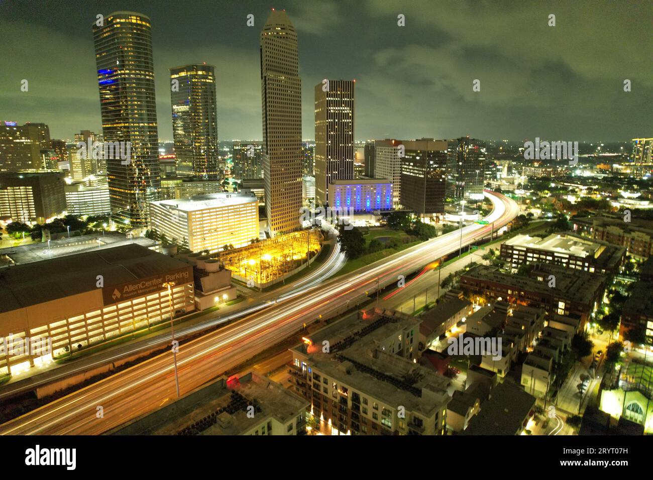 An aerial view of the vibrant Houston skyline at night with illuminated buildings across the ...