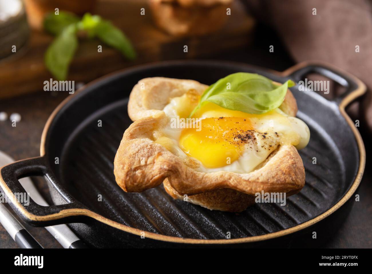 Scrambled eggs in puff pastry with cheese and bacon on a stone plate ...