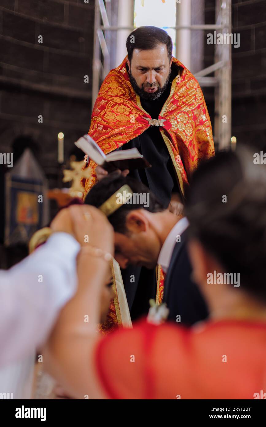 A Christian priest officiating a traditional wedding ceremony in an ...