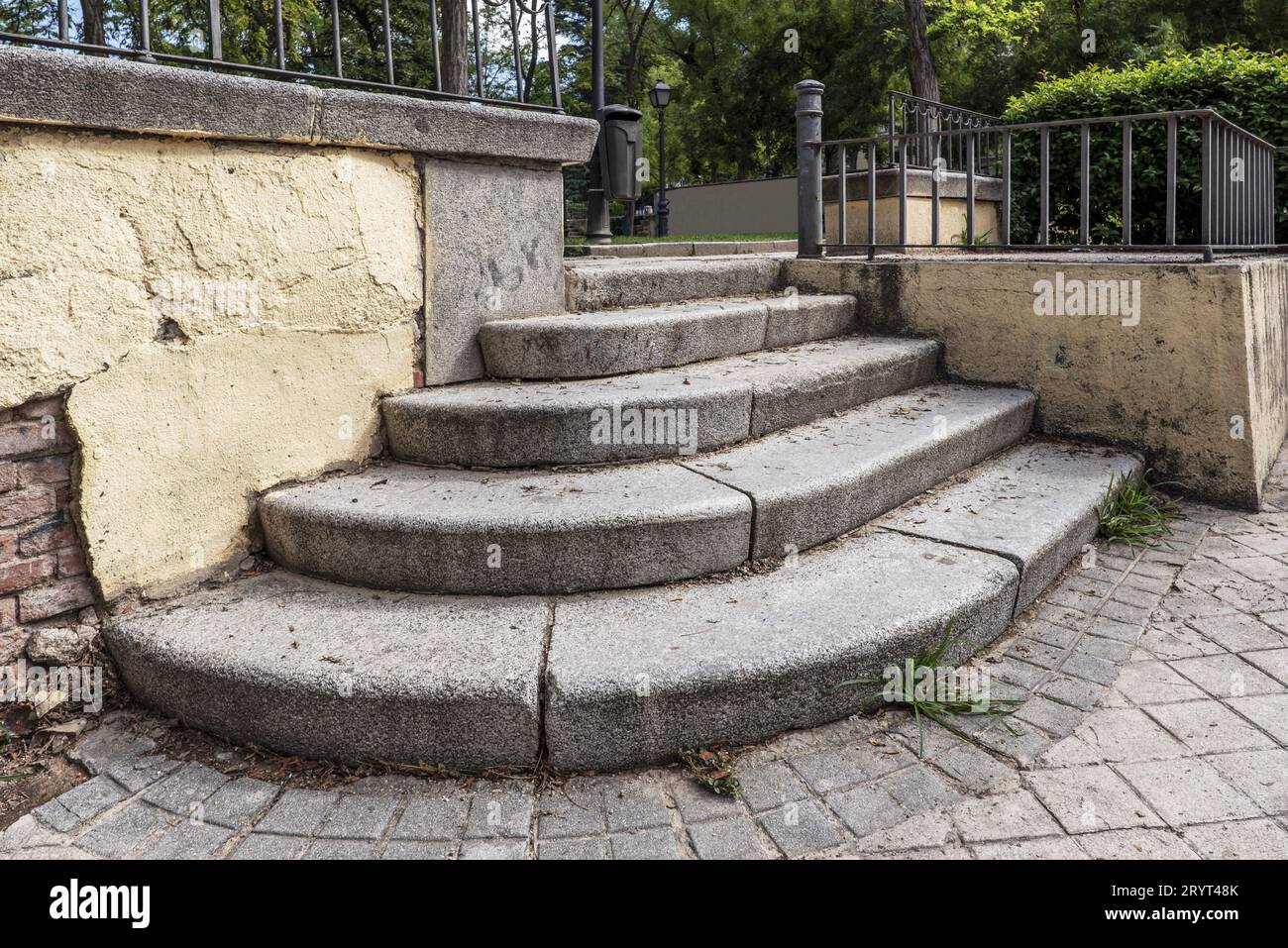 Old stairs with granite steps at the access from the street to an urban ...