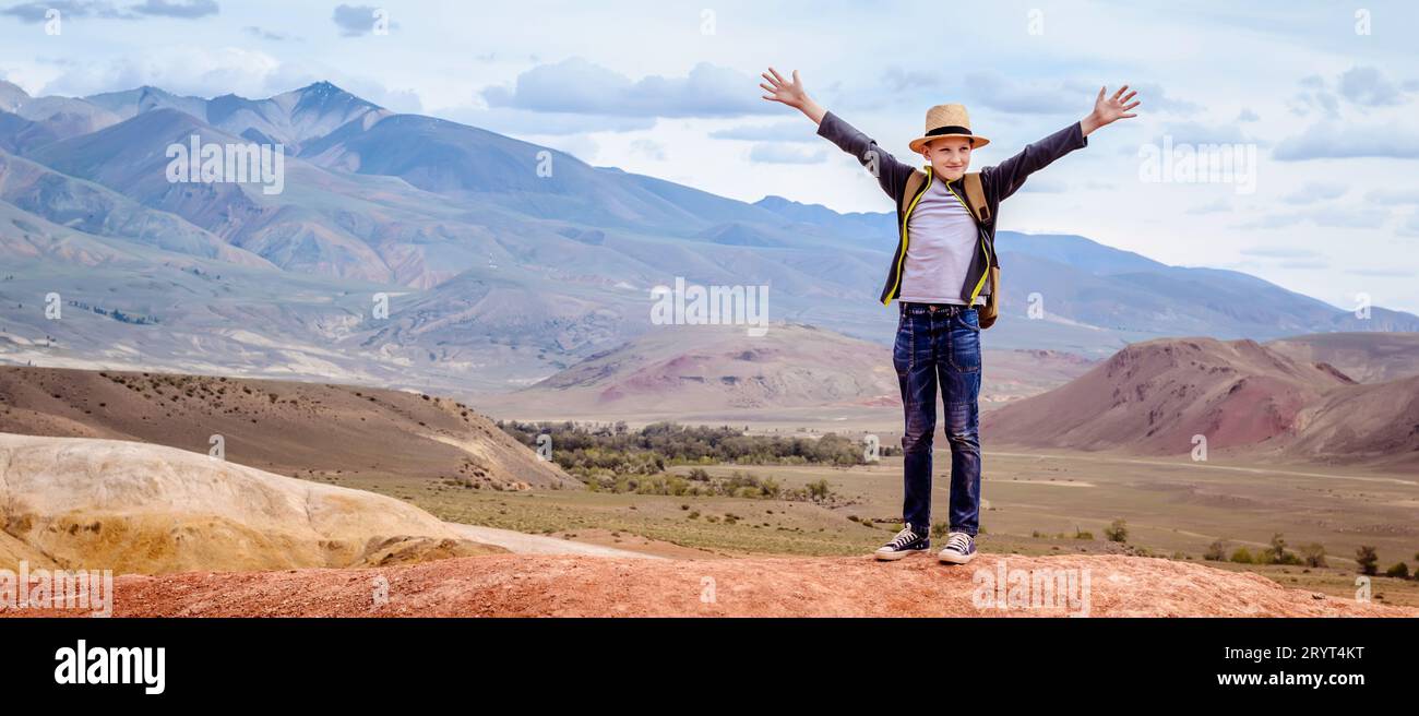 Happy traveler boy standing with raised arms and enjoying beautiful ...