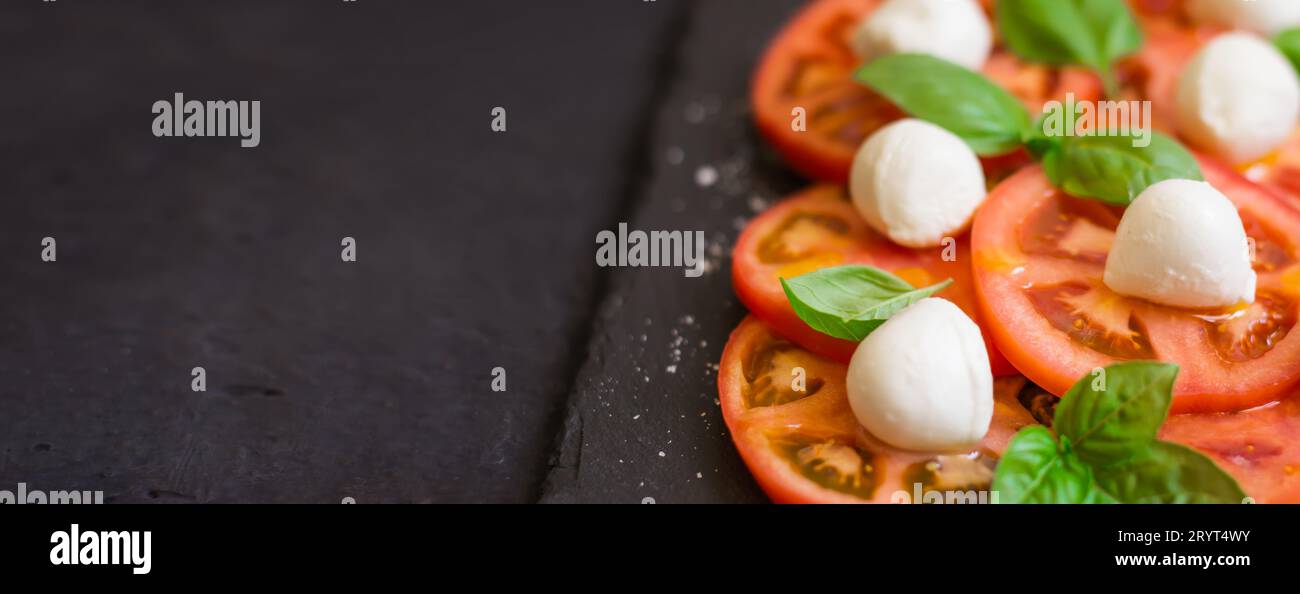 Fresh italian caprese salad on dark plate. Long format, selecti Stock ...