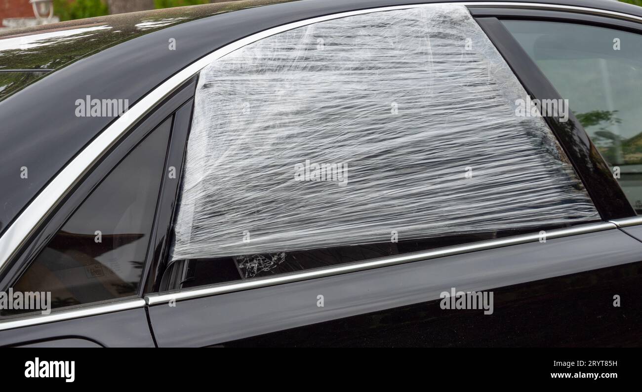 Broken car window is taped shut Stock Photo - Alamy