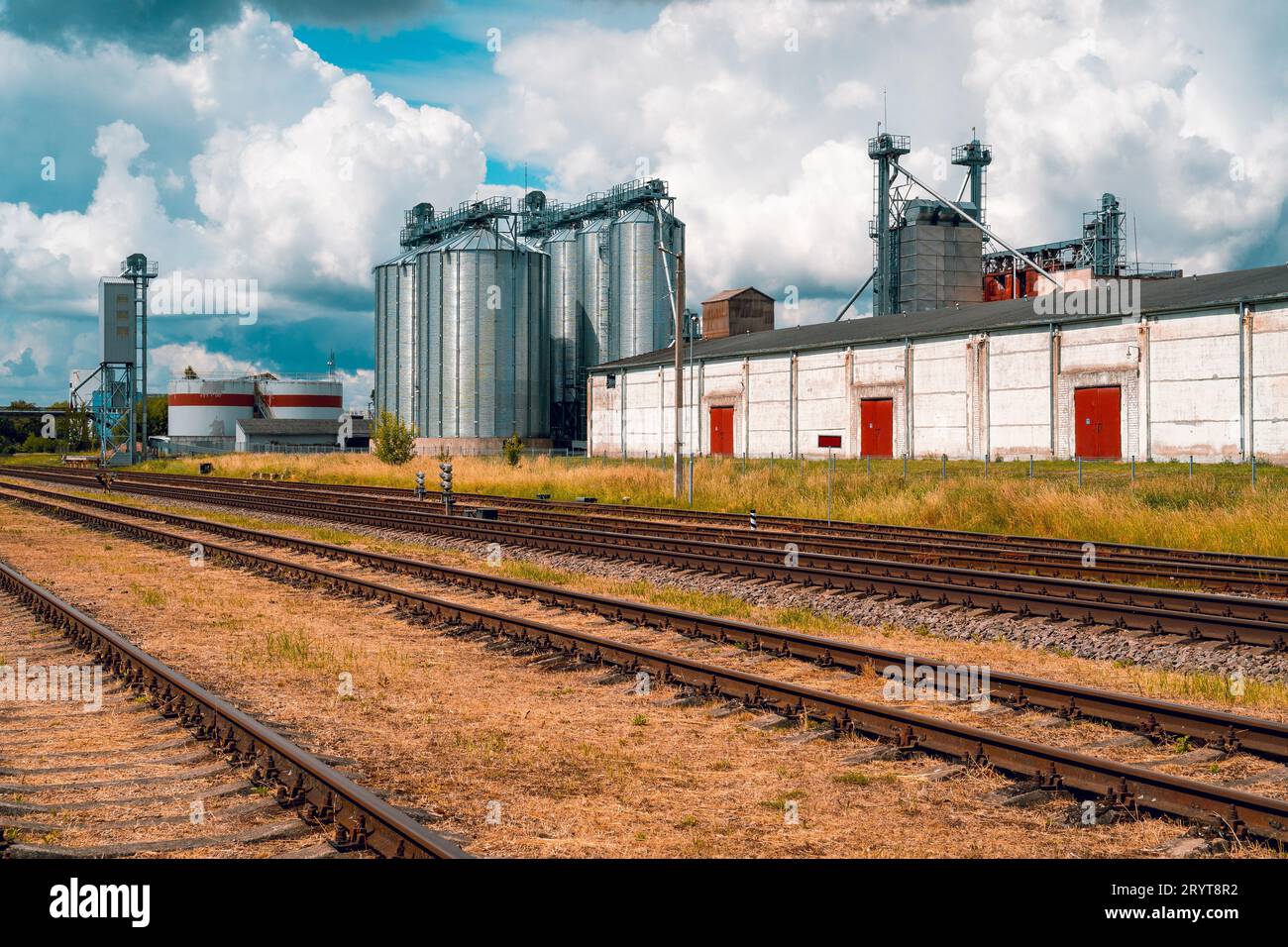 A railroad tracks passing near big steel silos Stock Photo - Alamy